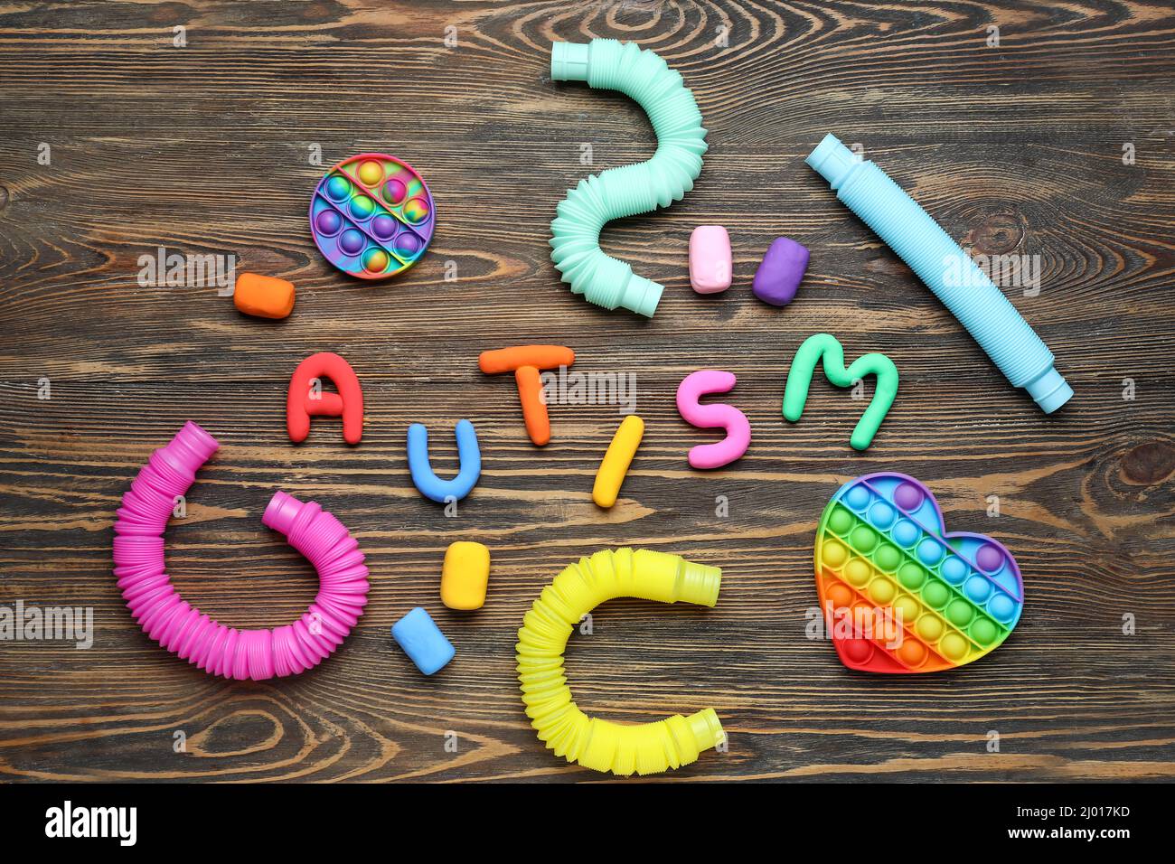 Word AUTISM with toys on dark wooden background Stock Photo - Alamy