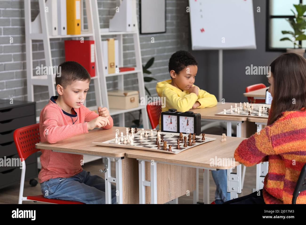 Little children playing chess during tournament in club Stock Photo - Alamy