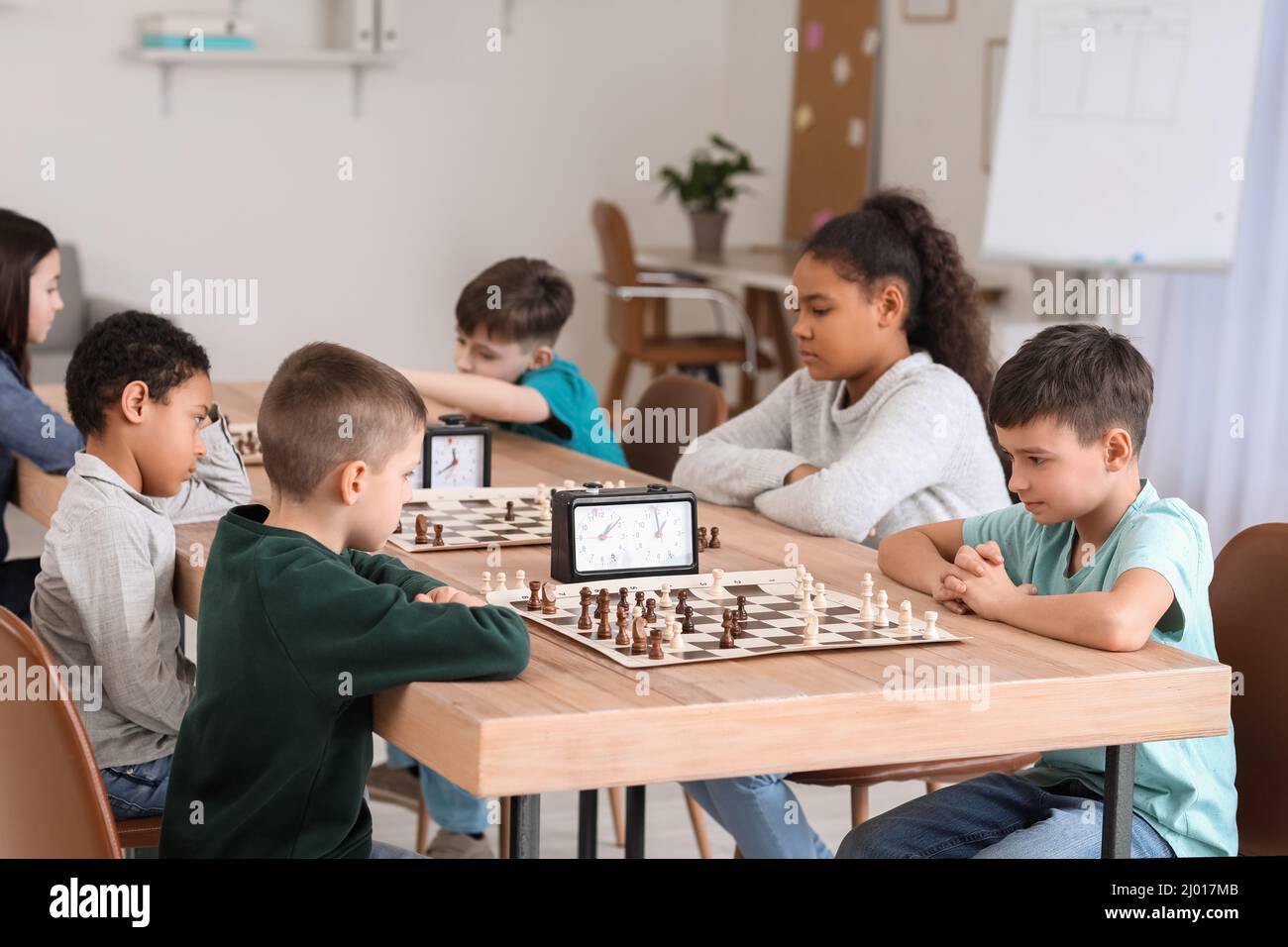 Little children playing chess during tournament in club Stock Photo - Alamy