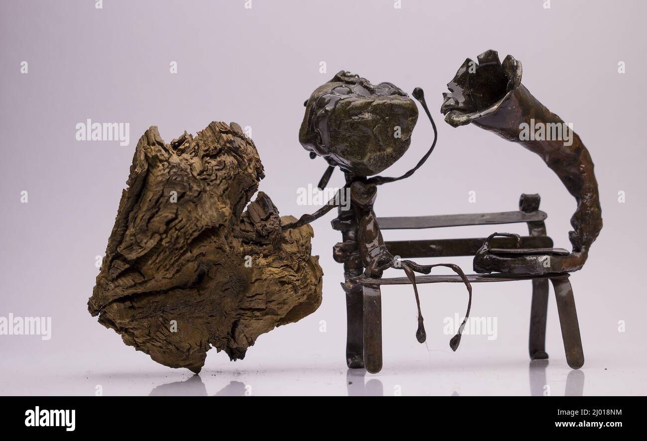 Small brass figurine of a person listening to a gramophone on a bench ...
