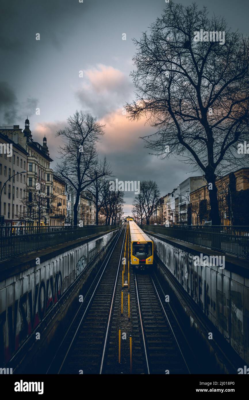 Vertical shot of a yellow train on tracks at sunset in Berlin Stock ...