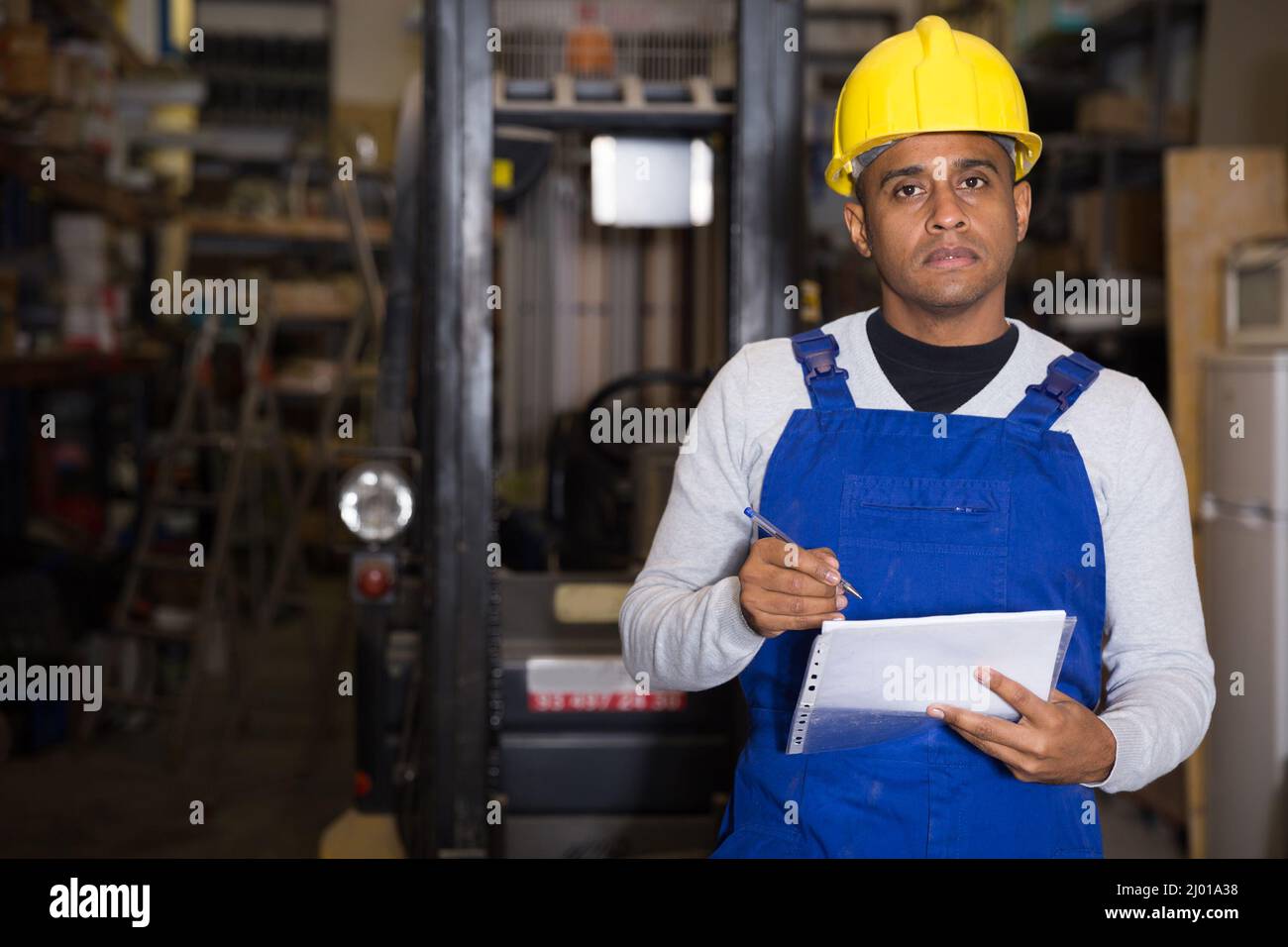 Warehouse manager calculates the quantity of goods and writes it down ...