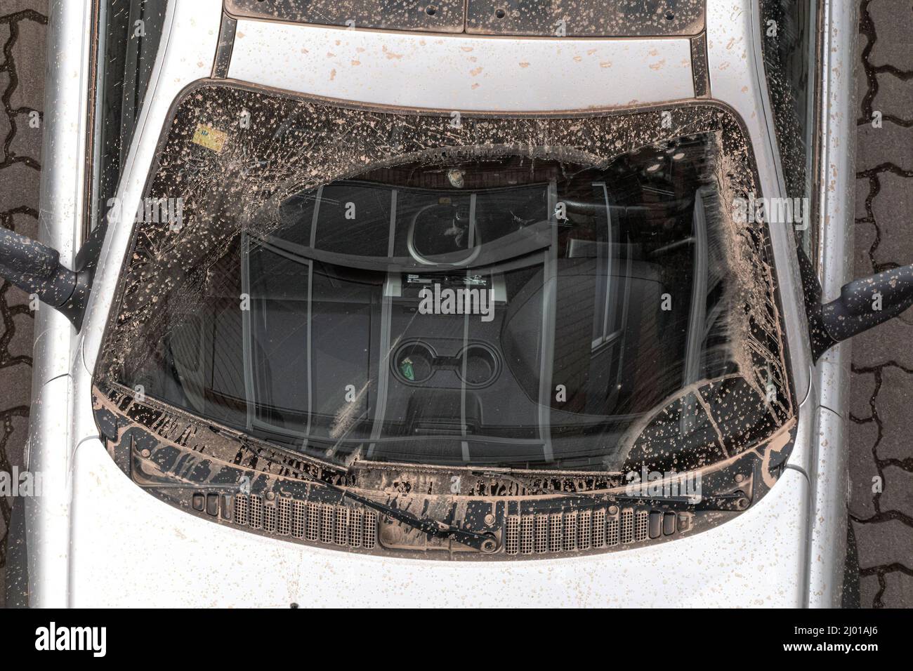 A car covered with sand as the city wakes up with cars, floors and ...