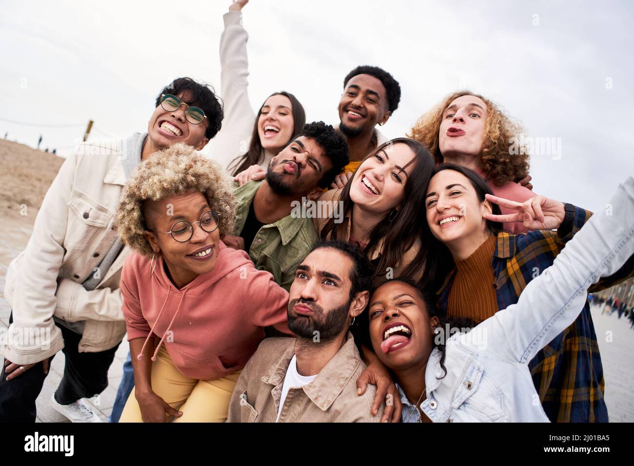 Big group of cheerful young friends taking selfie portrait fool around ...