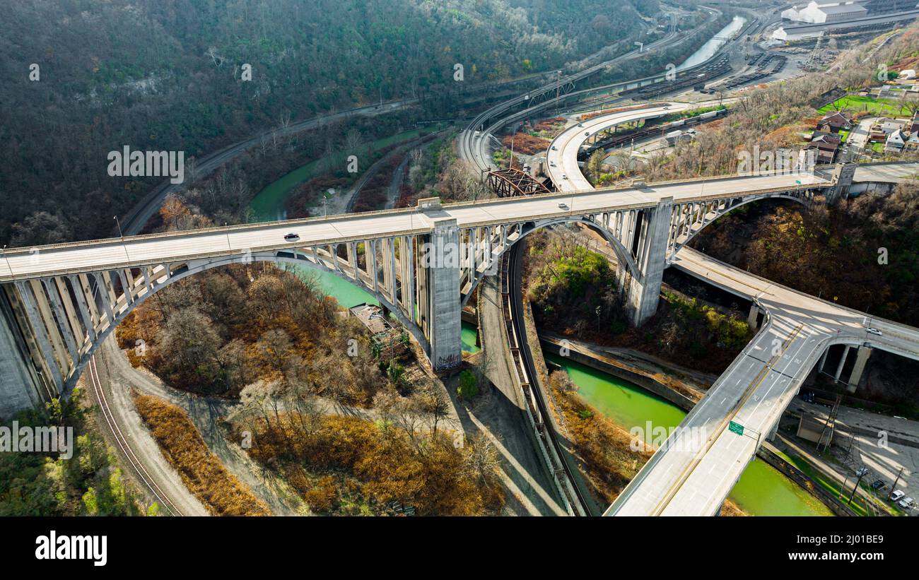 Aerial shot of urban elevated bridges roads over green forest and ...