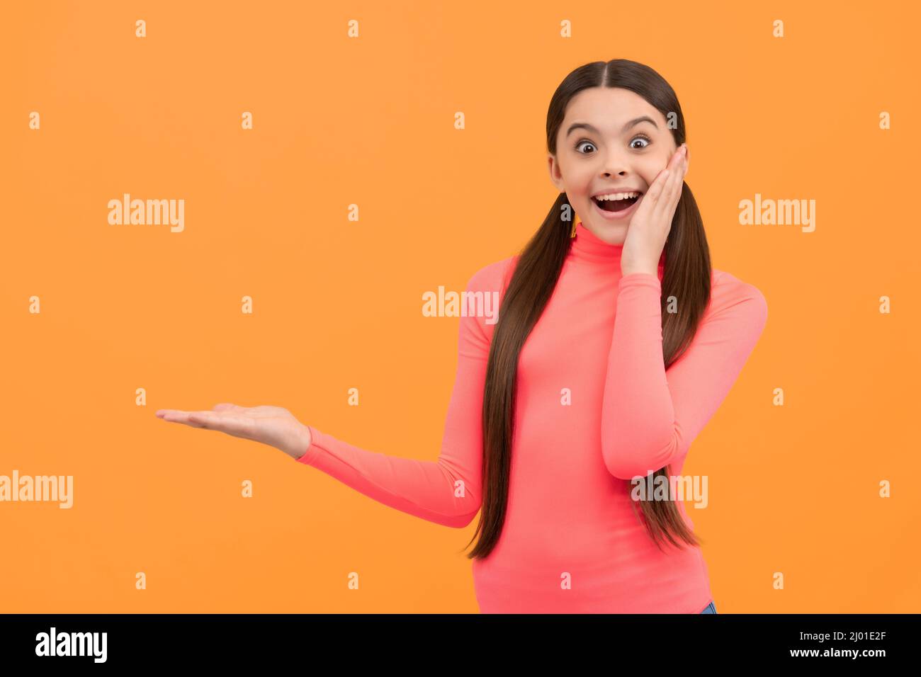 pretty teen girl advertising on yellow background. portrait of happy ...