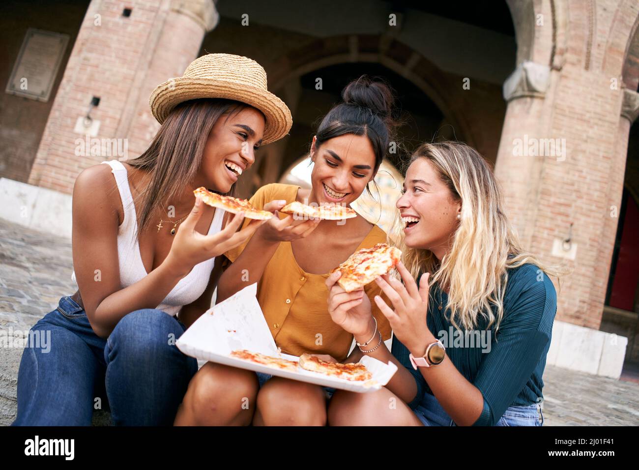 Funny group of three girls eating pizza in the city Stock Photo - Alamy
