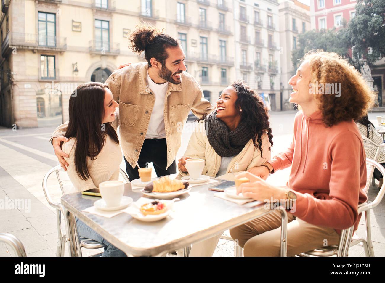 Group of friends meet in the street. People having breakfast outdoors ...