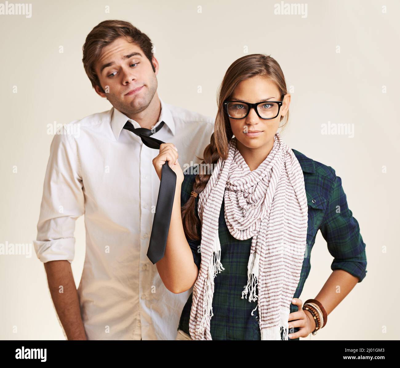 Im your master. An angry hipster woman holding her boyfriend by the tie ...