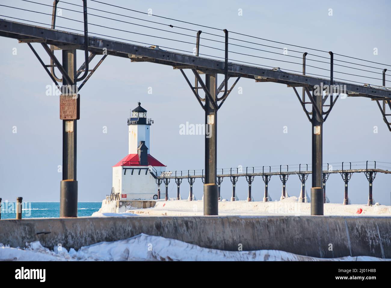 Winter view of red and white lighthouse through walkway railing Stock ...