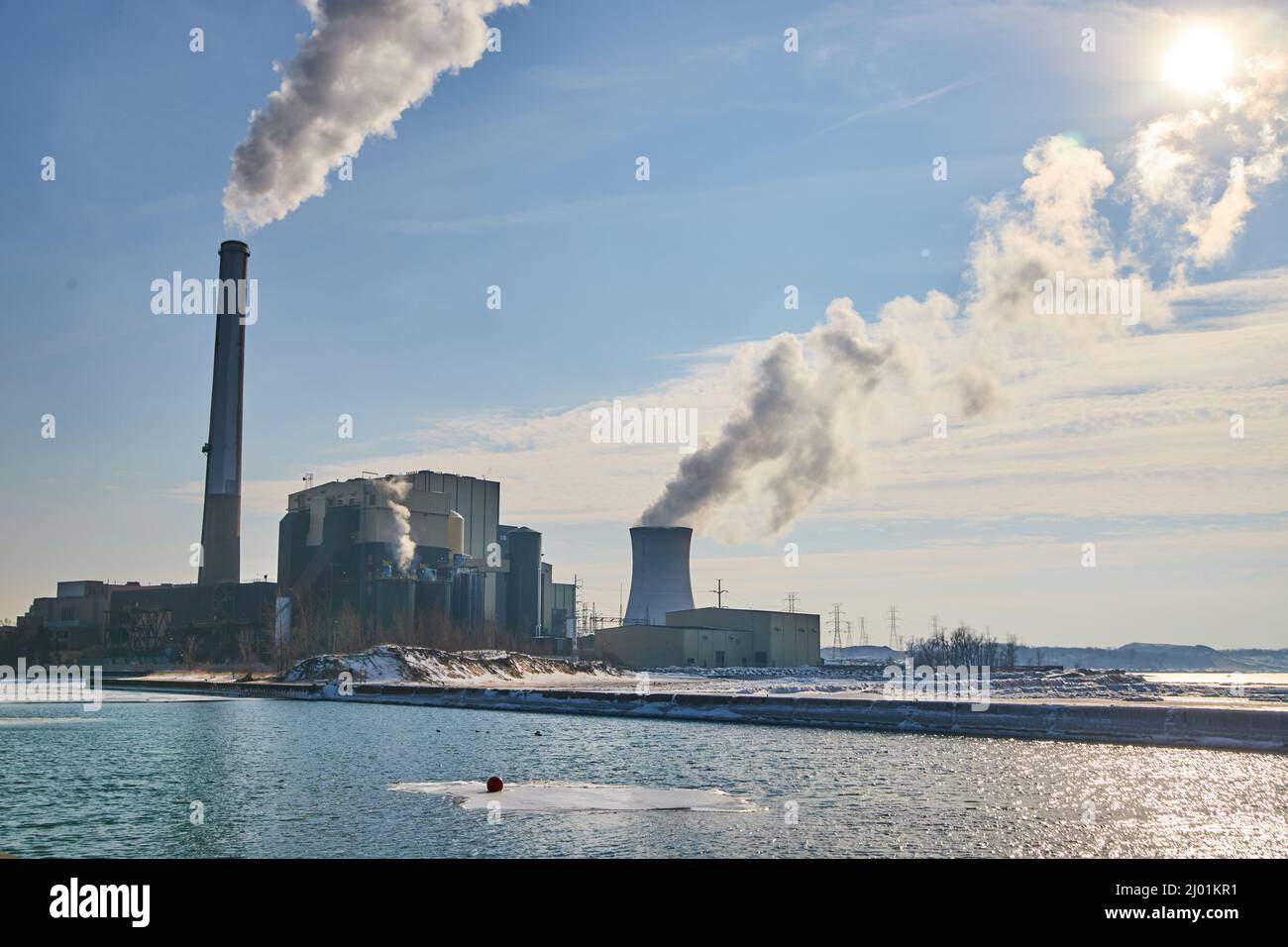 Large factory on water with two silos Stock Photo - Alamy