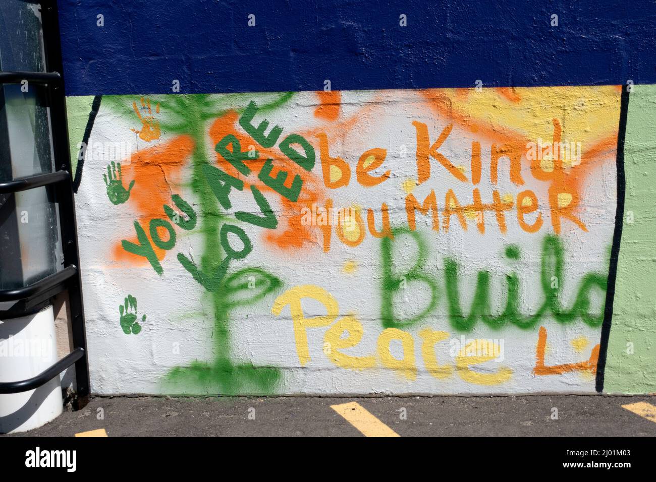 Graffiti sign on a building "you are loved" "be kind you matter". St ...