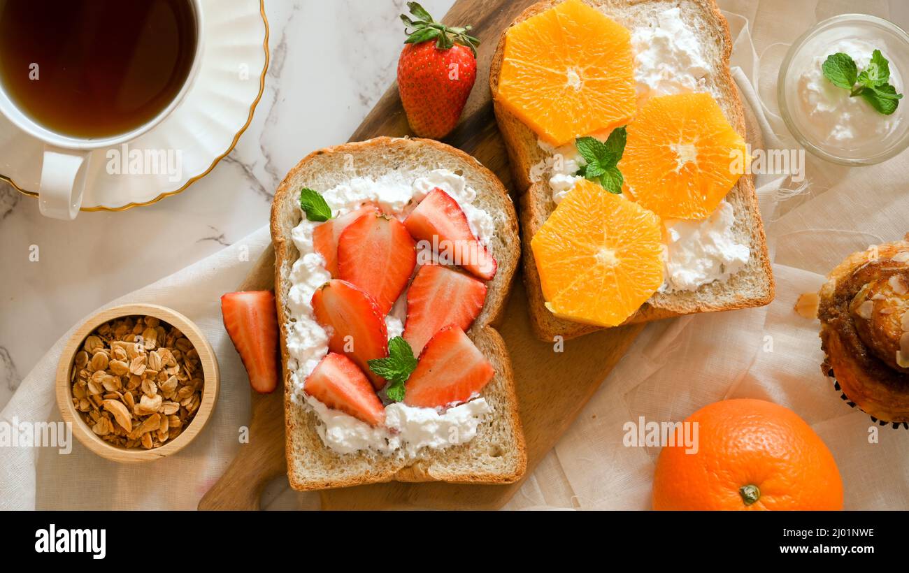Healthy breakfast set with strawberry toast with soft cheese, orange ...