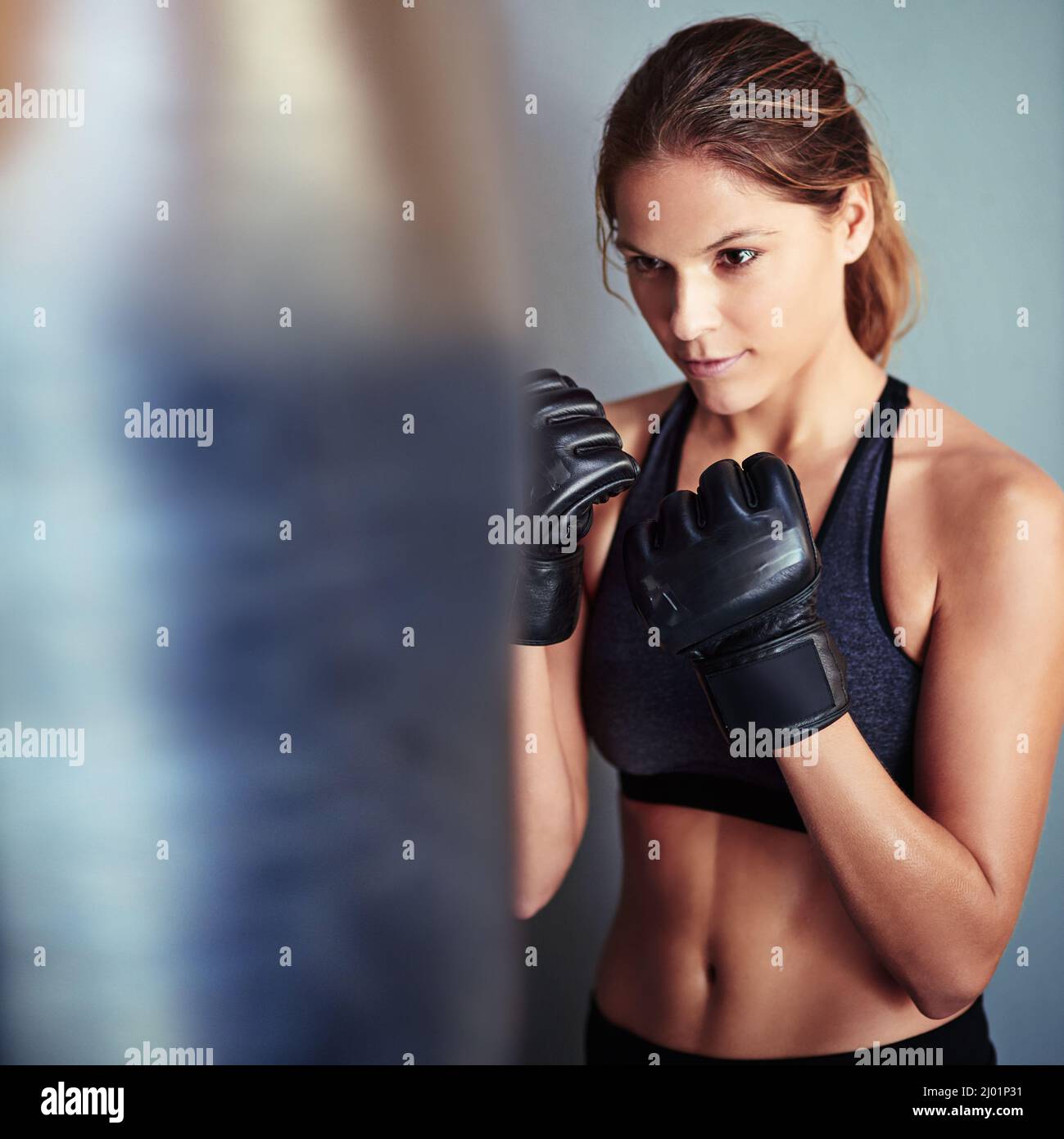 Power comes from good technique. Shot of a female boxer working out ...