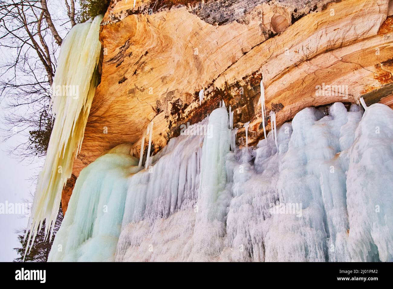 Rock wall in winter covered in blue ice formations Stock Photo - Alamy