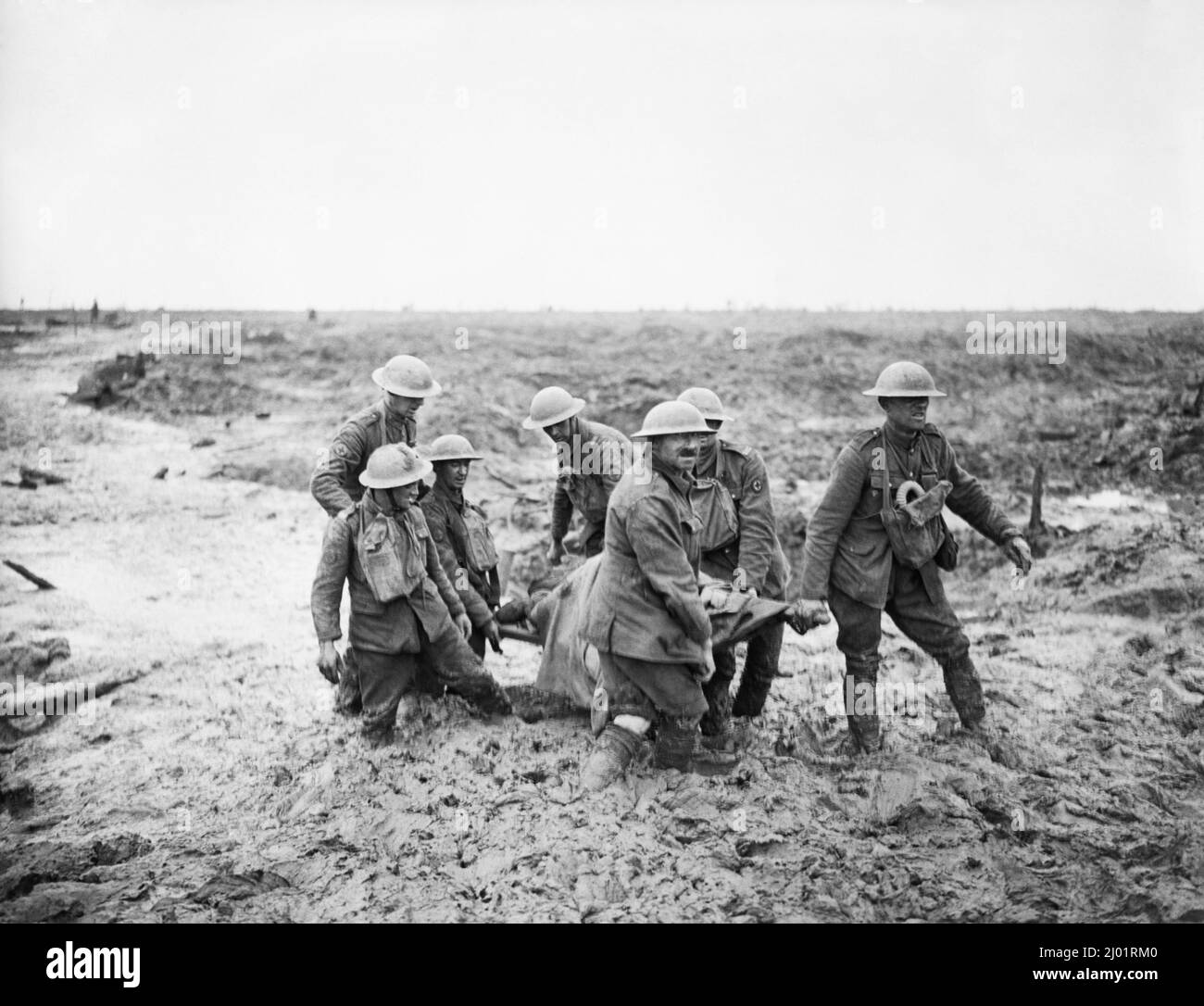 A team of stretcher bearers struggle through deep mud to carry a ...