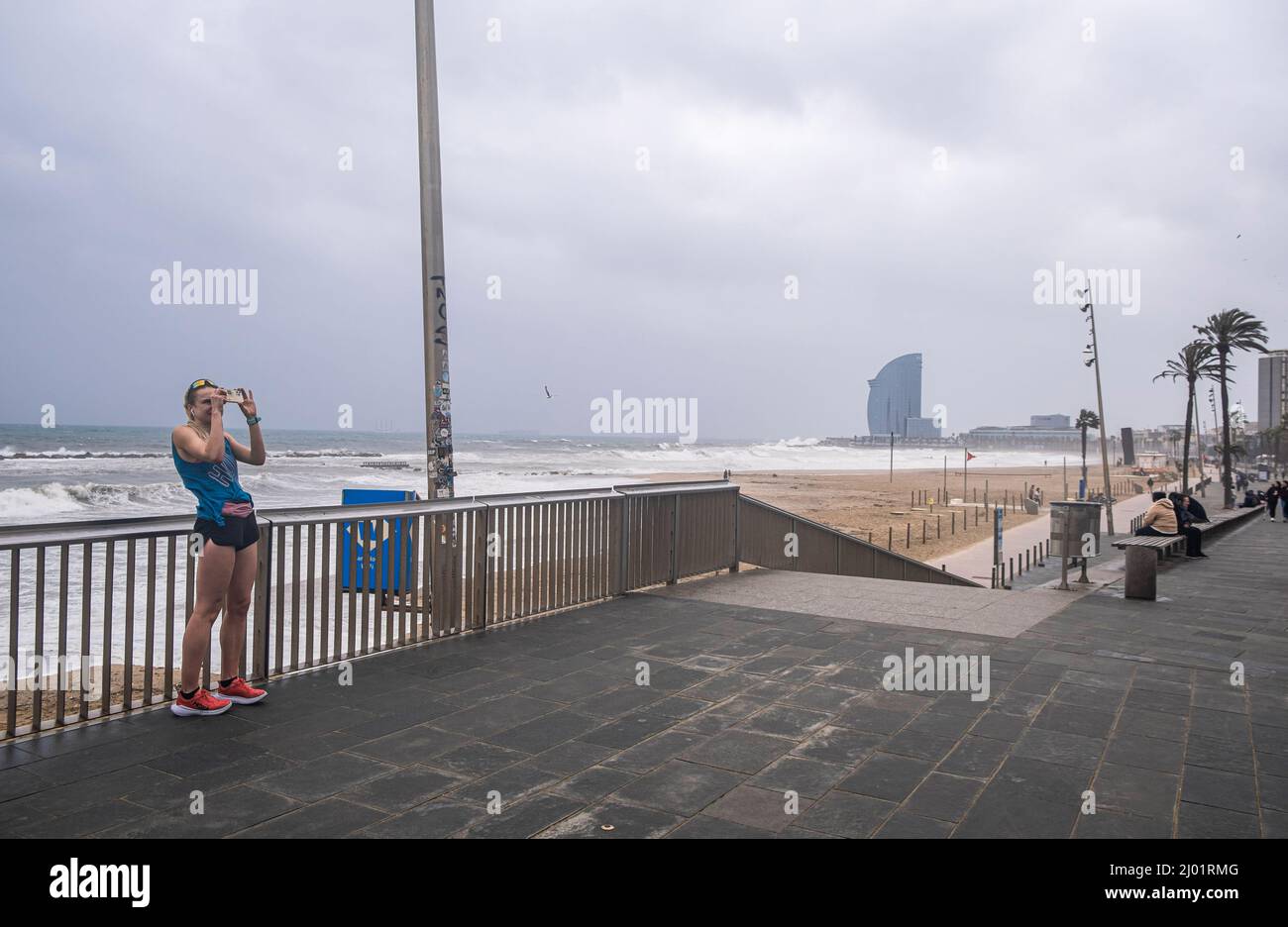 A sporty-dressed woman is seen taking pictures of stormy Celia ...