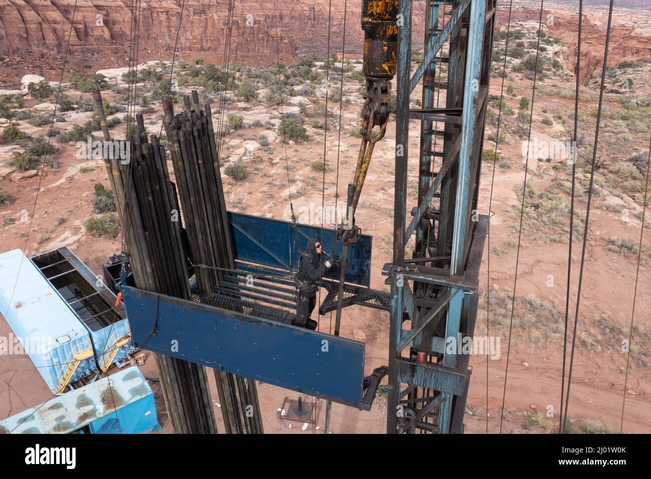 Derrickman attaching tubing to travelling block Stock Photo - Alamy