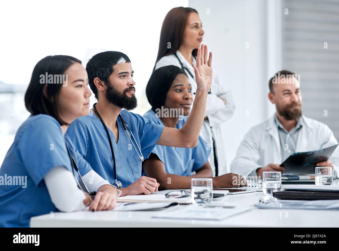 Asking probing questions about the problem. Shot of a doctor raising ...