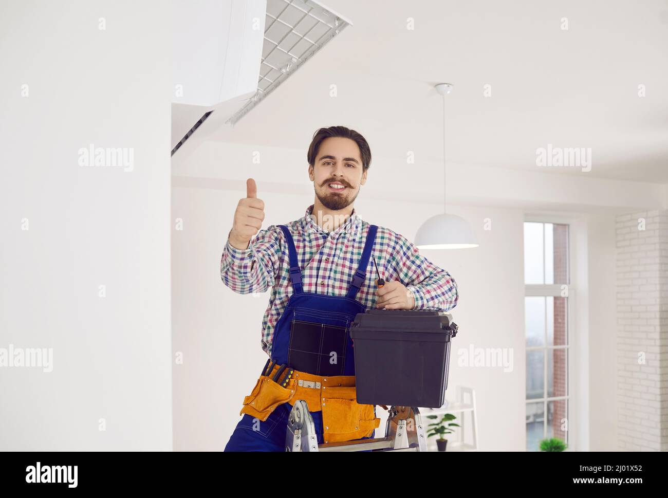 Happy AC maintenance service worker showing thumbs up after repairing ...