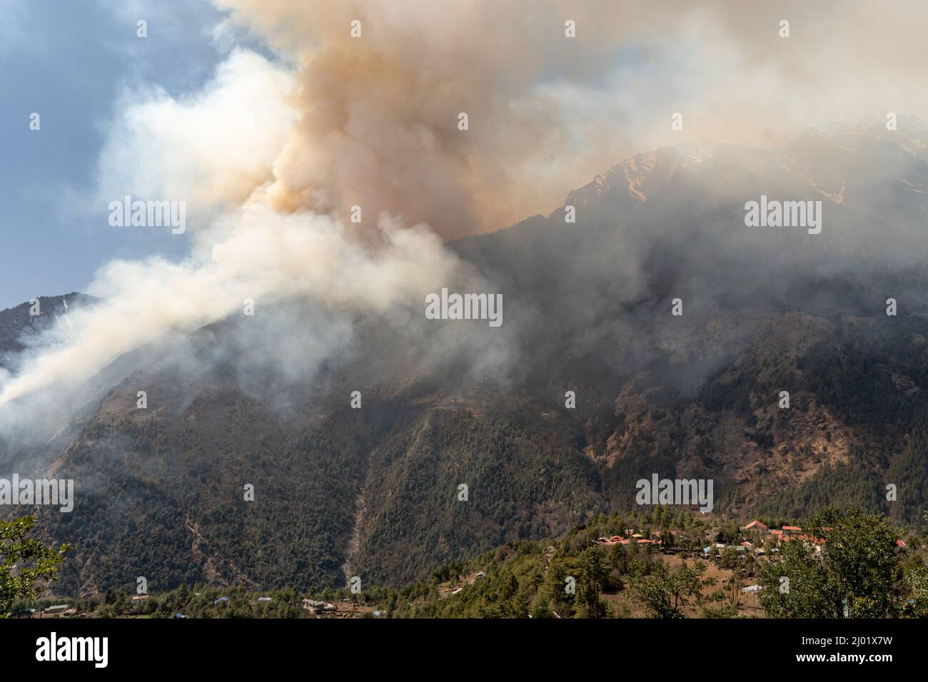 The smoke from a forest fire filling the sky over a mountain in Nepal ...