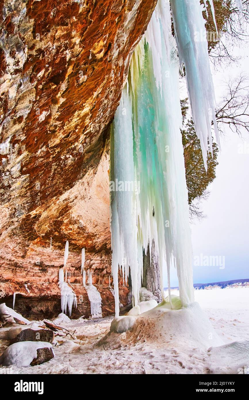 Cave opening in cliffs during winter with large icicles dangling Stock ...