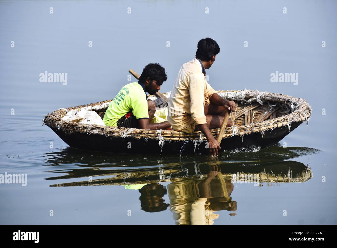 A bot and bot men in river Stock Photo - Alamy