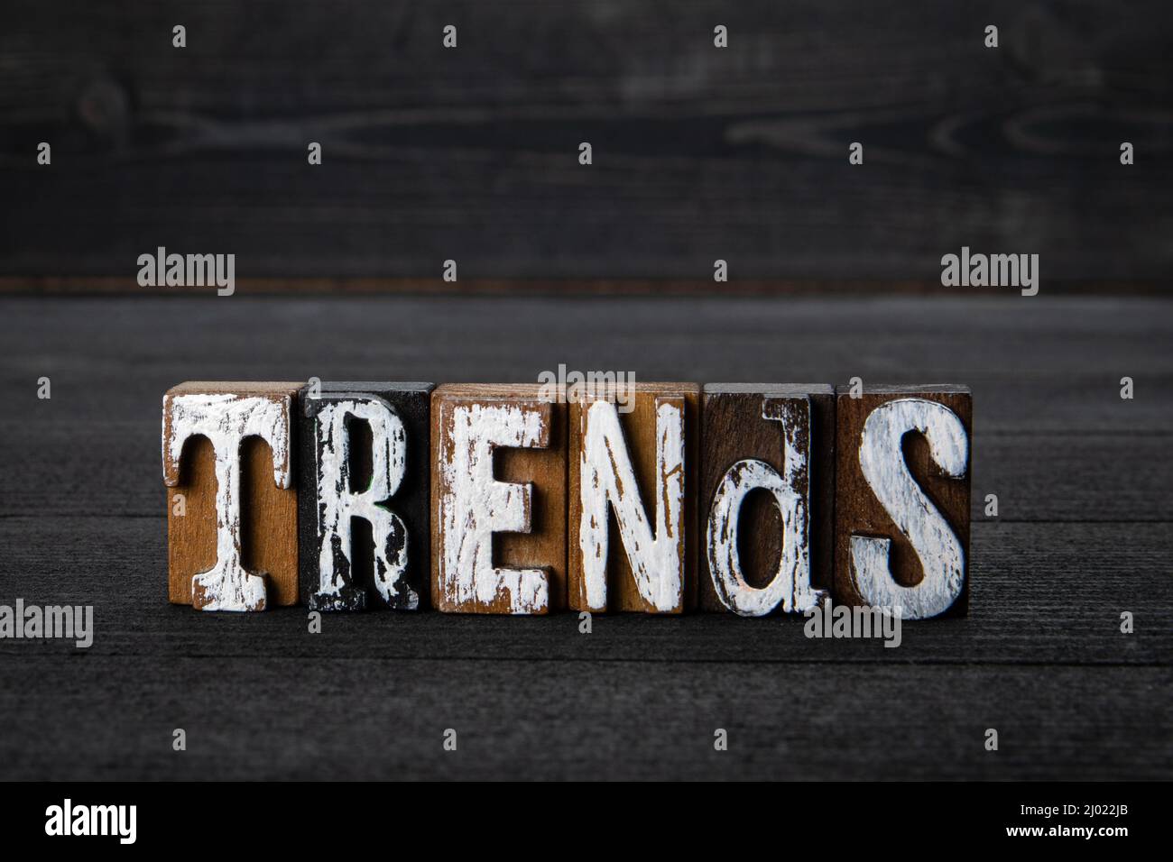 Trends. Text from wooden alphabet blocks on a dark textured background ...