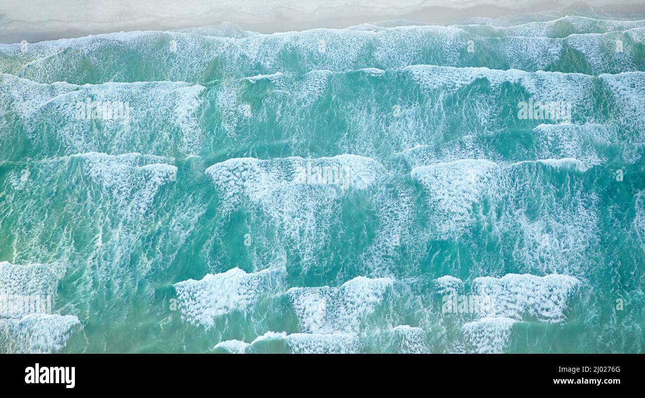 Ebb and flow of the sea. Aerial view of ocean waves moving toward the ...