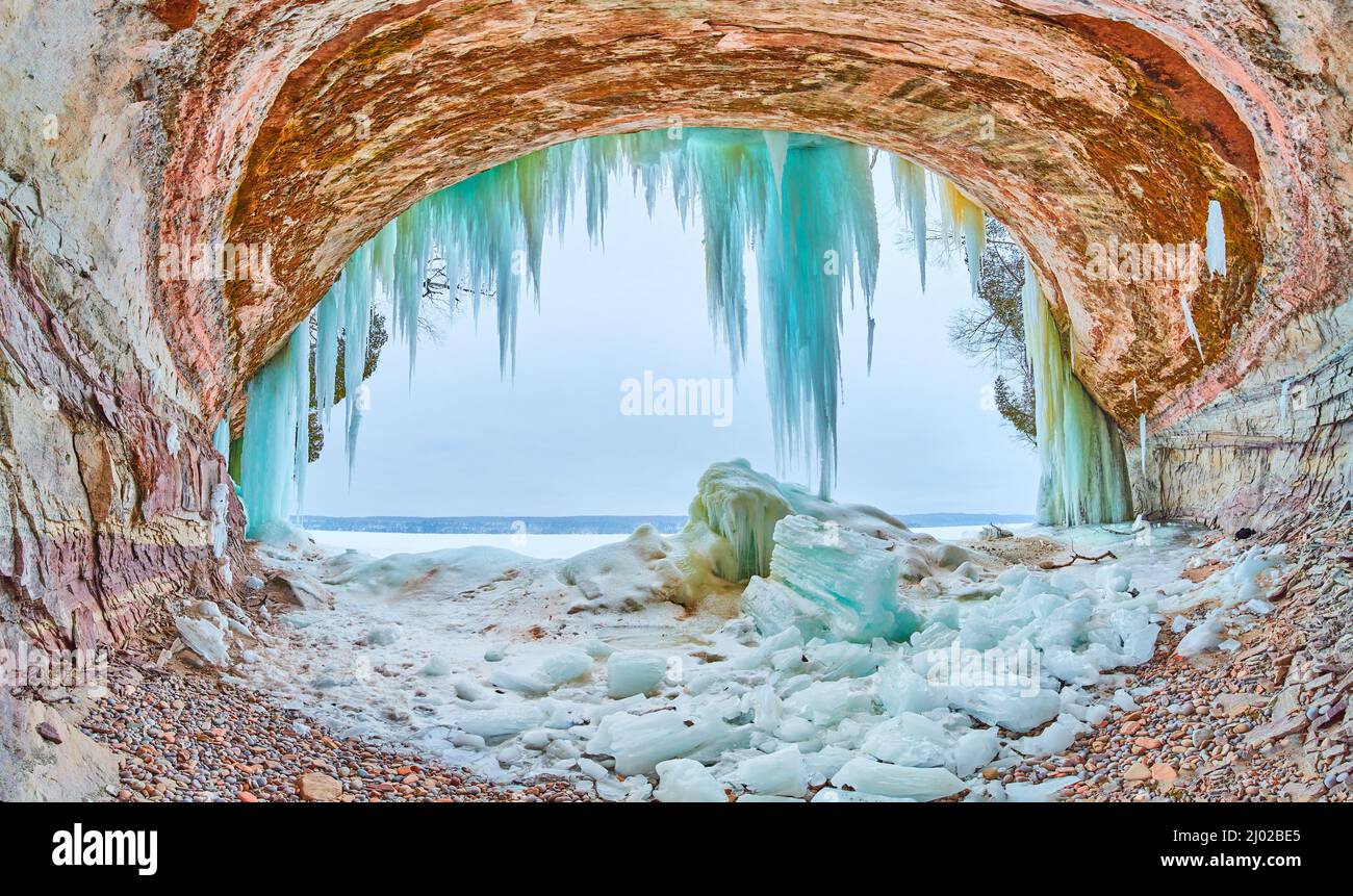 Opening to large ice cave in Michigan with blue and green icicle ...