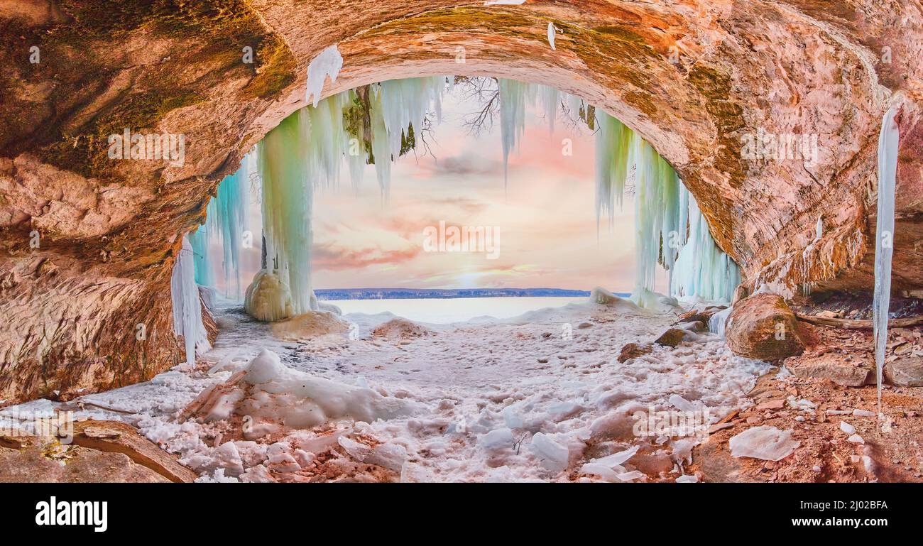 Beautiful ice cave during sunrise in winter with large blue and green ...