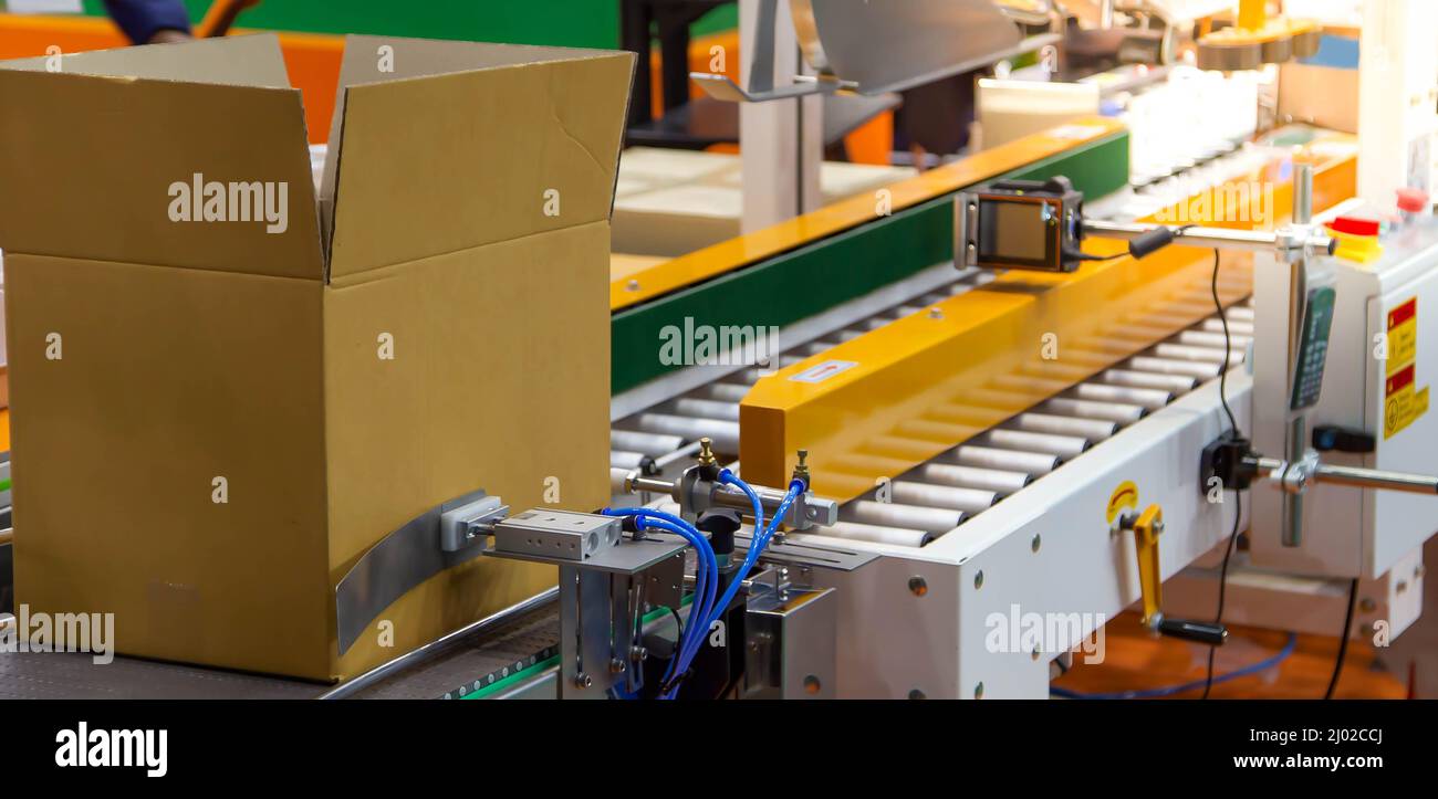 Production line of carton packing and sealing machine Stock Photo - Alamy