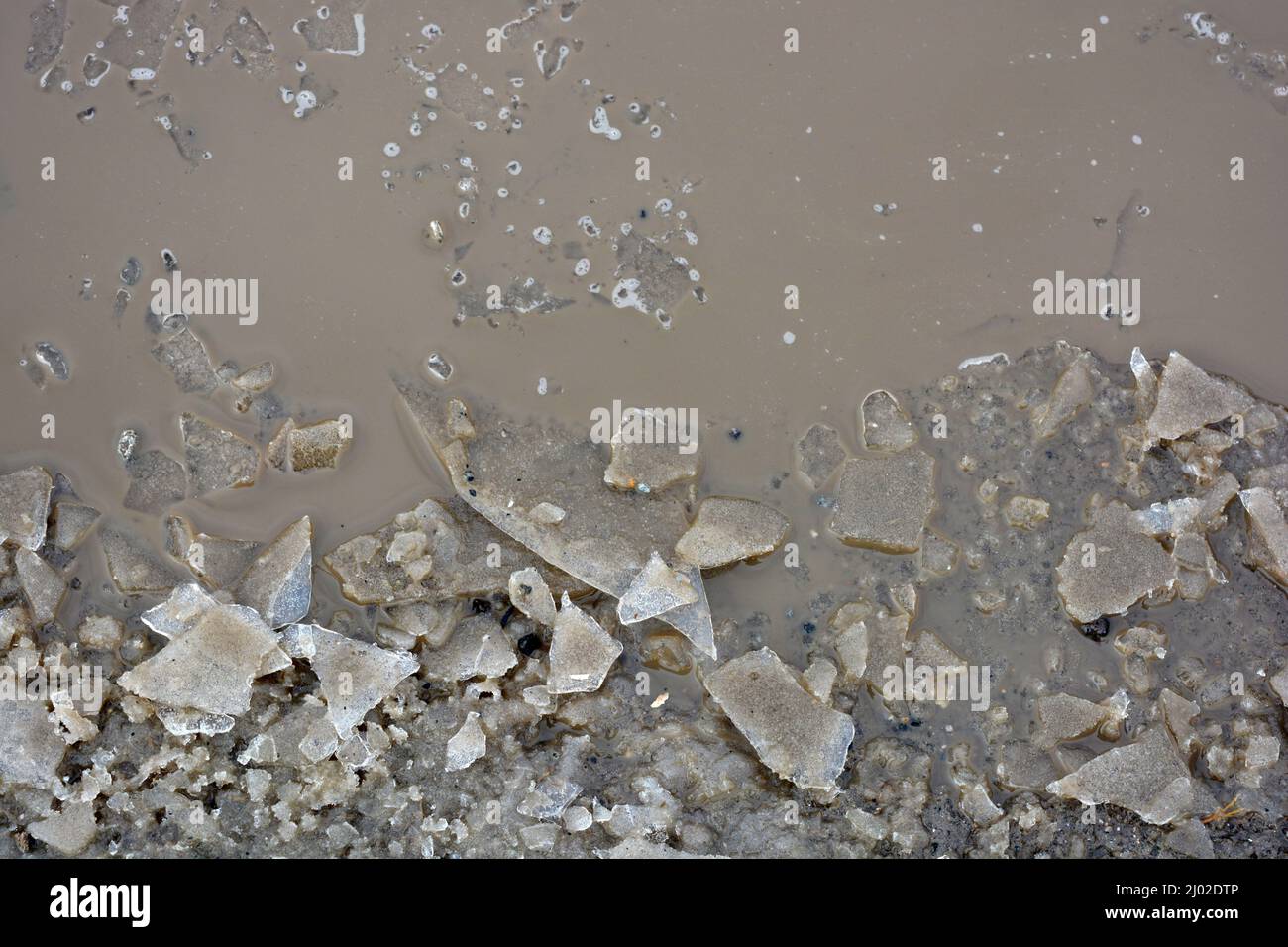 Broken transparent ice, small pieces of ice crust lie near a frozen ...