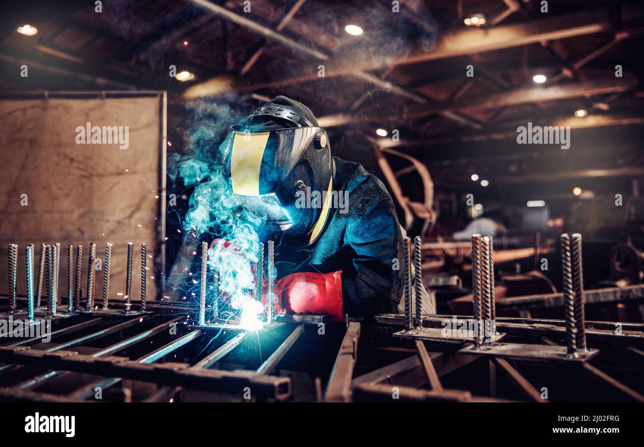 Factory industrial weld worker in workplace with spark. Professional ...