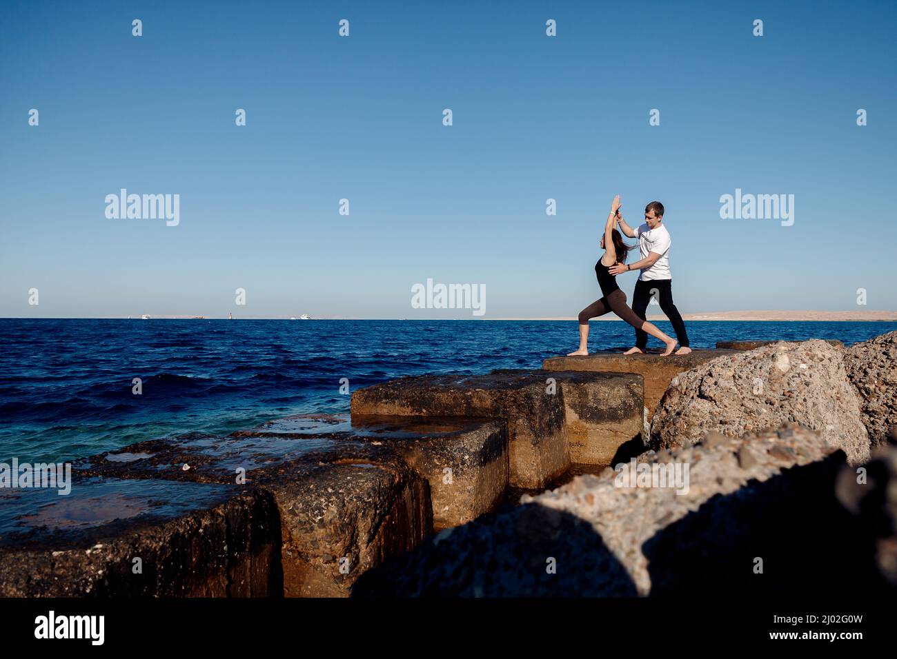 Personal trainer man correct woman client while doing stretching or ...