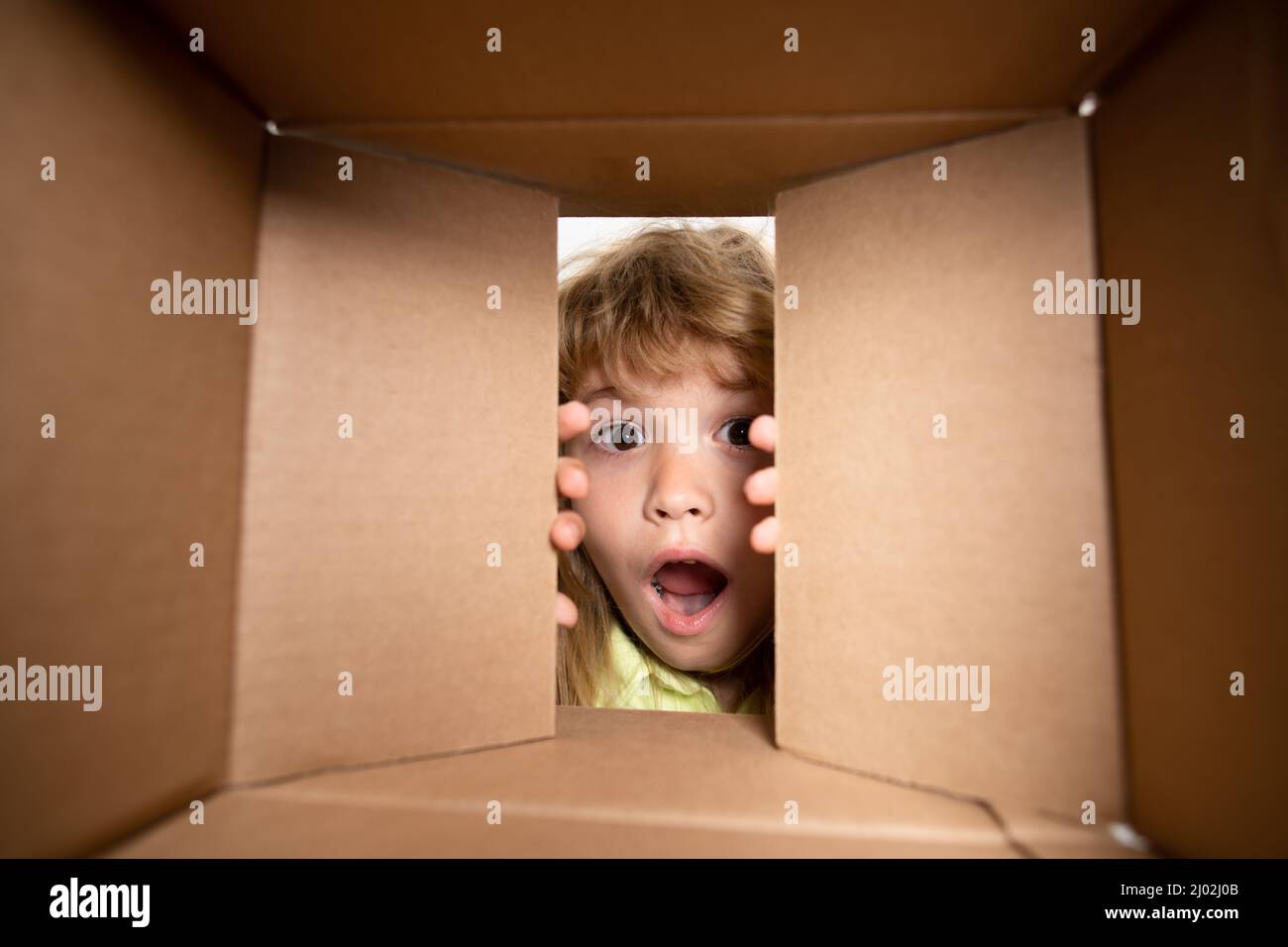 Kid opening package. Child boy age 6 year opening a carton box and ...