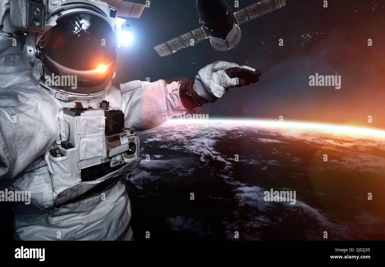 Astronaut at spacewalk against international space station. Science ...