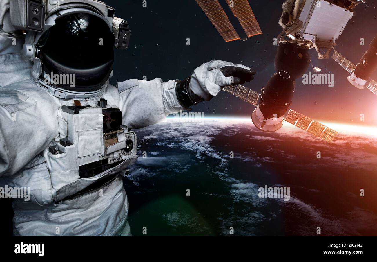Astronaut at spacewalk against international space station. Science ...