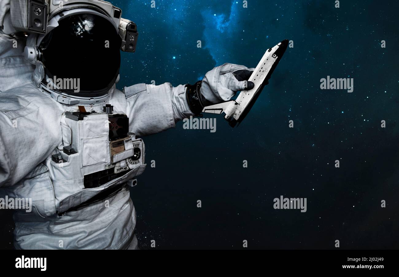 Astronaut with toy Shuttle in his hand. Science fiction art. Elements ...