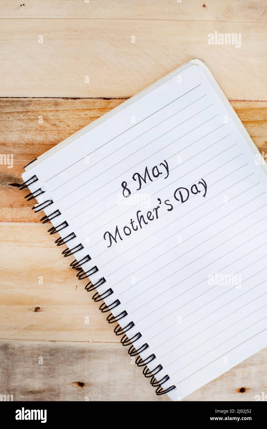 8 May Mother's Day written on notebook page with rustic backdrop Stock ...