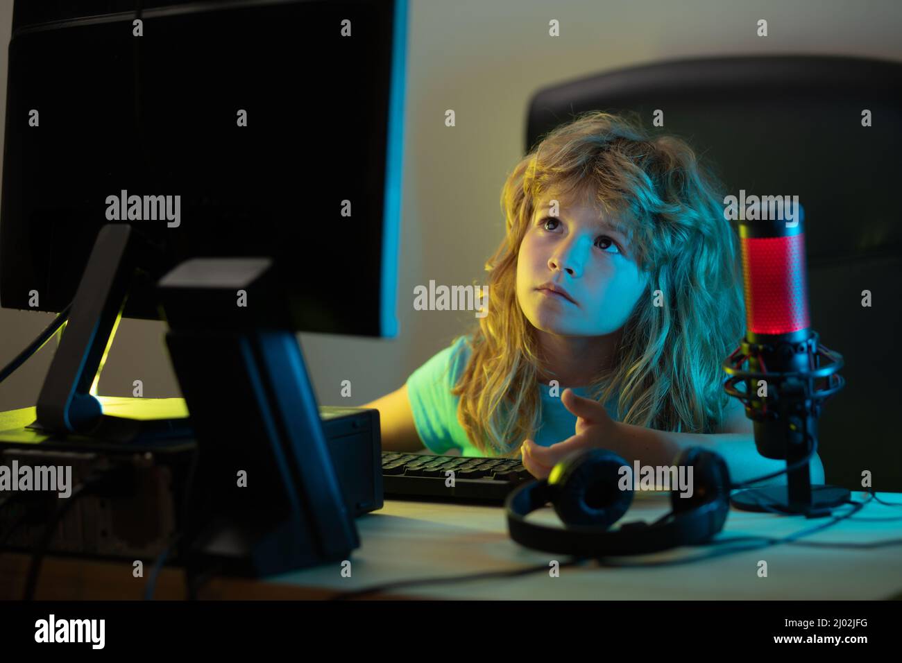 Little child gamer play computer game on desktop. Gaming stream and ...