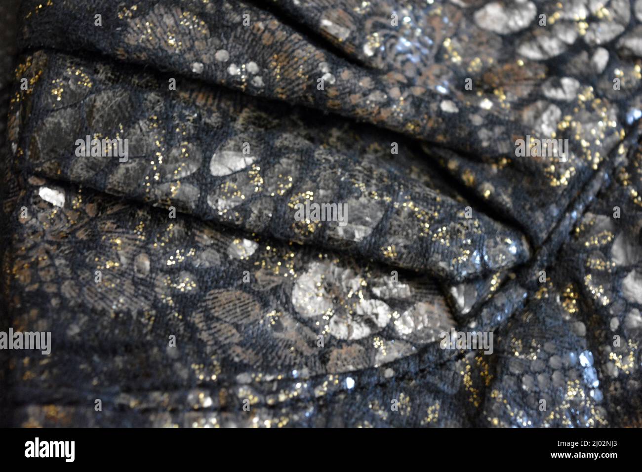 Black dark fabric background with gilding, gold flower patterns with ...