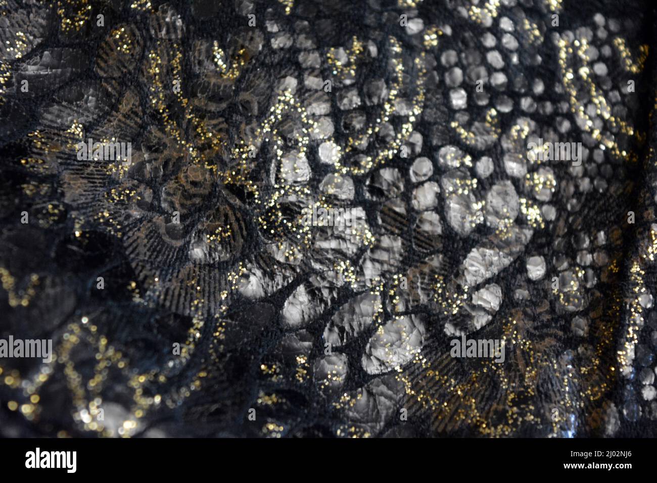 Black dark fabric background with gilding, gold flower patterns with ...