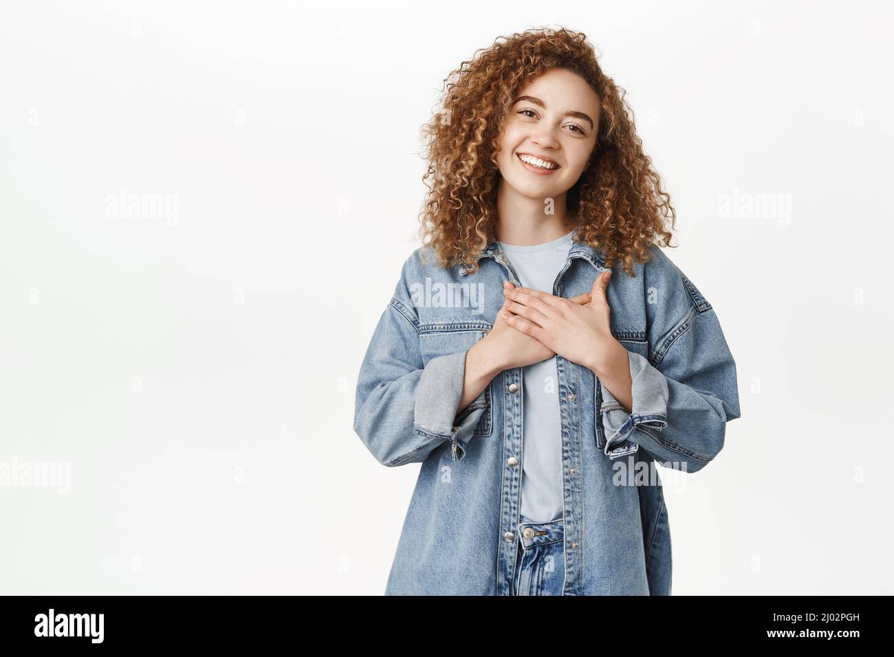 Portrait Of Happy Young Woman Smiling Holding Hands On Heart In