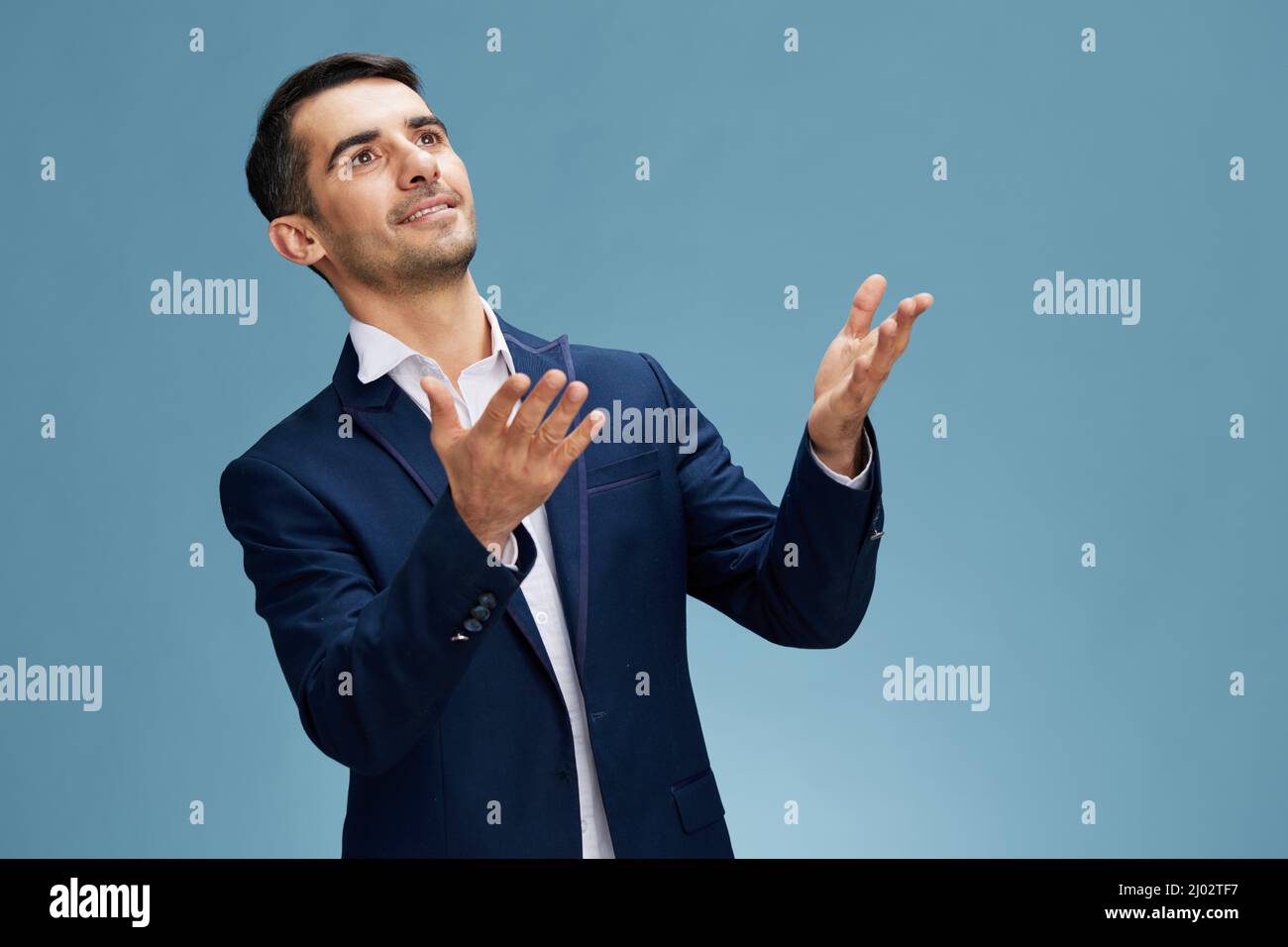a white man in a business suit with his head held high holds his hands ...