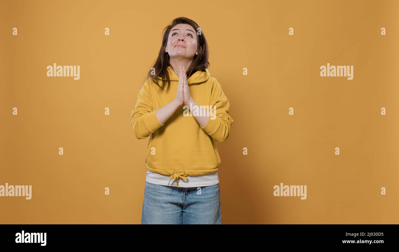 Casual woman feeling worried, looking up praying and asking for ...