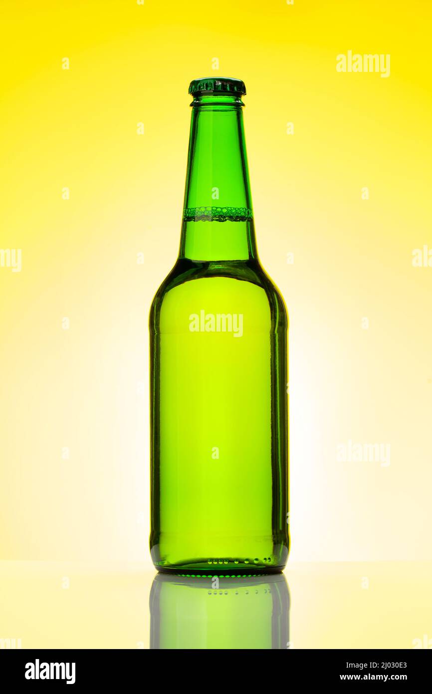 Beer bottle in front of green background. Studio shot Stock Photo - Alamy