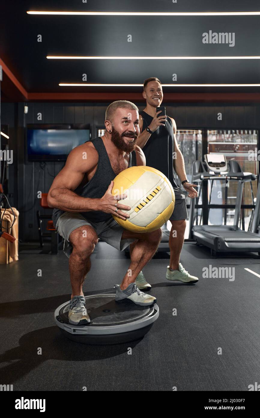 The guys tries to keep his balance on the balancing platform with ...