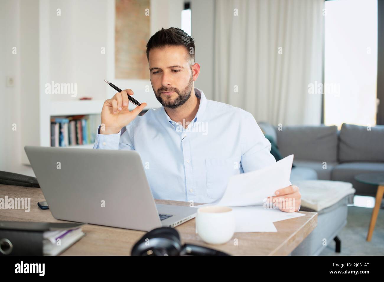 Candid shot of handsome man sitting behind his laptop while working ...