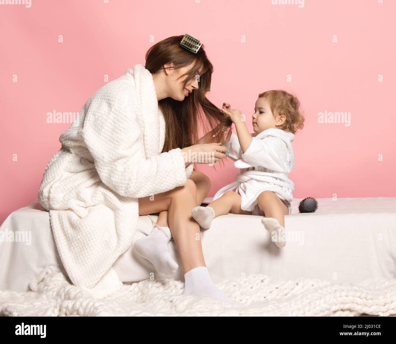 Young beautiful happy woman and little kid, mother and daughter wearing ...